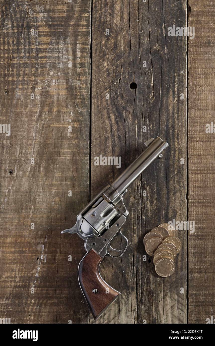 Cowboy wild west six gun and gold coins on old wooden boards Stock ...