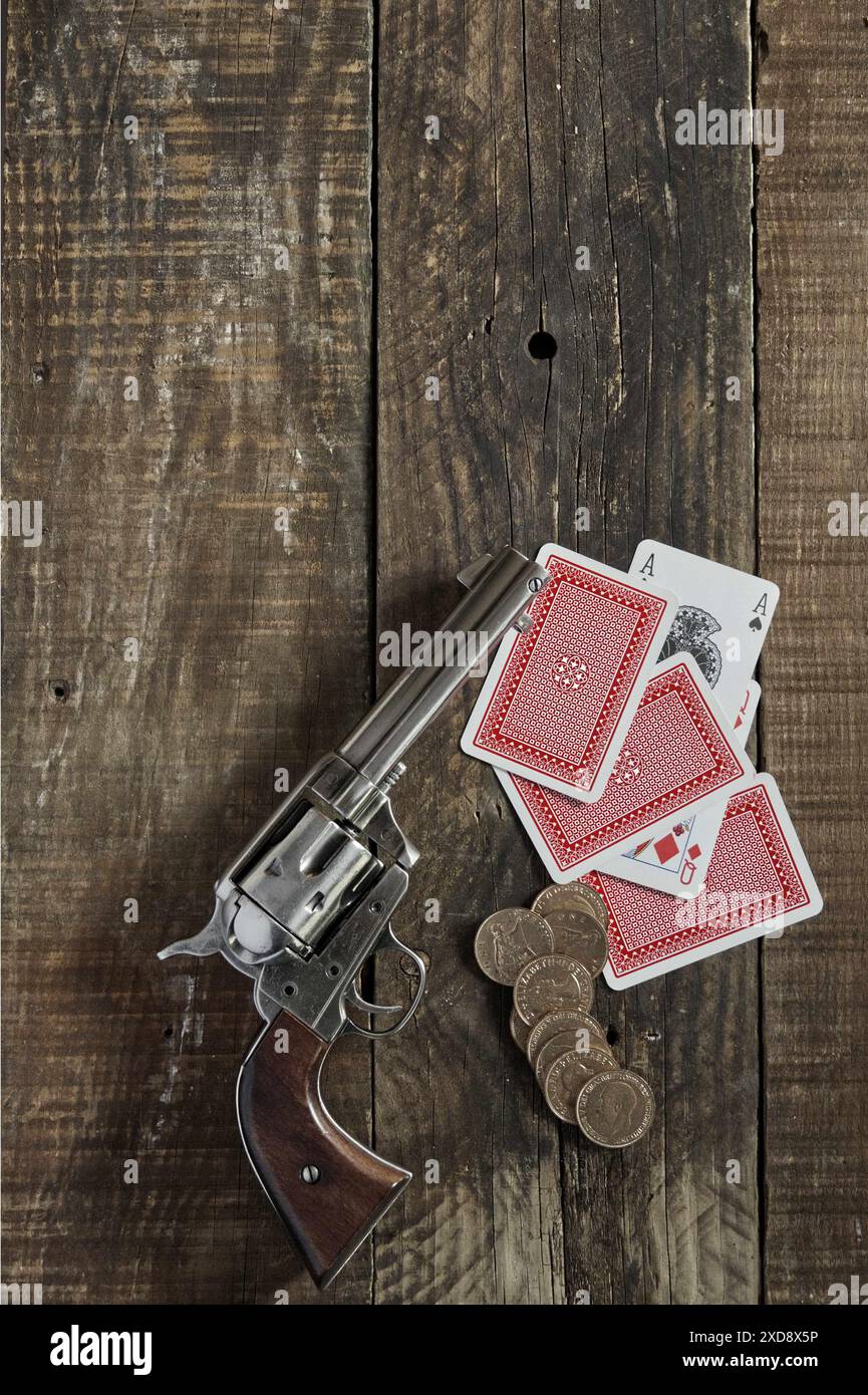 Wild west poker still life. six gun cards and coins Stock Photo - Alamy