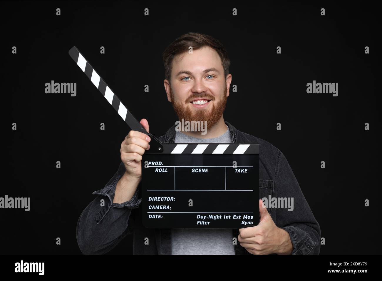 Making movie. Smiling man with clapperboard on black background Stock ...