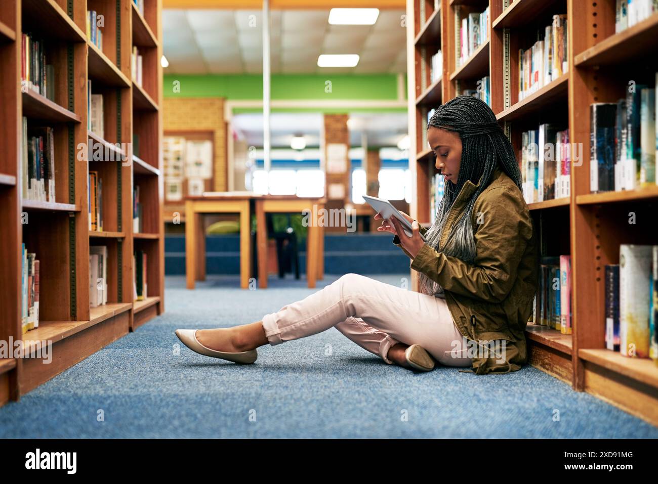 Tablet, woman and reading in library for research, education and ...