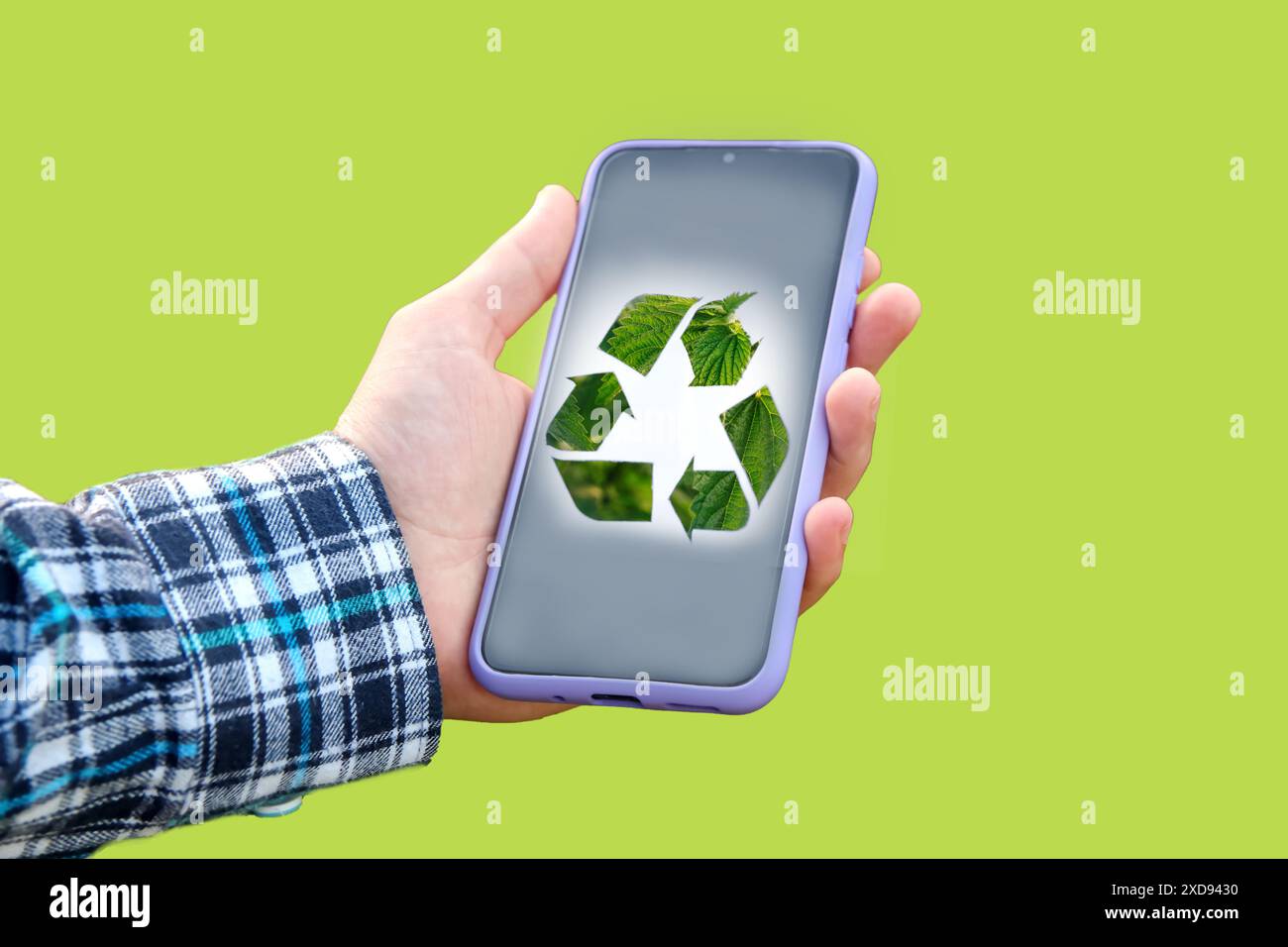 Male hand holding a smartphone with recycle symbol on light green ...