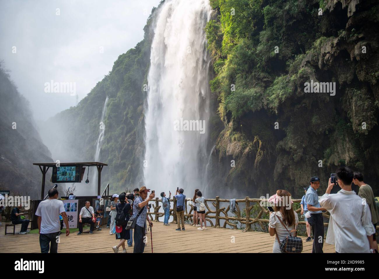 XINGYI, CHINA - JUNE 21, 2024 - Tourists view a waterfall at the Maling ...