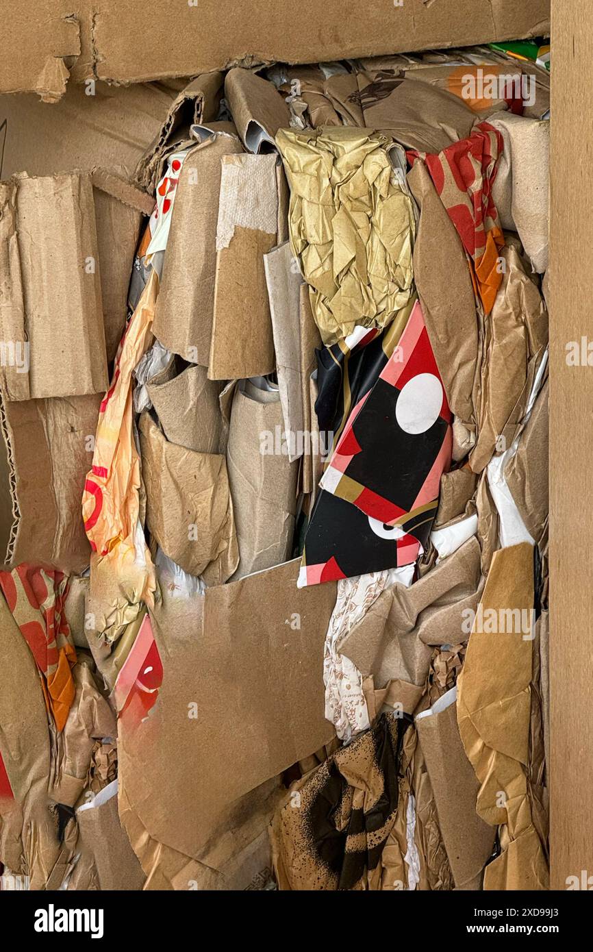 A tightly compressed bale of mixed cardboard and paper packaging ...