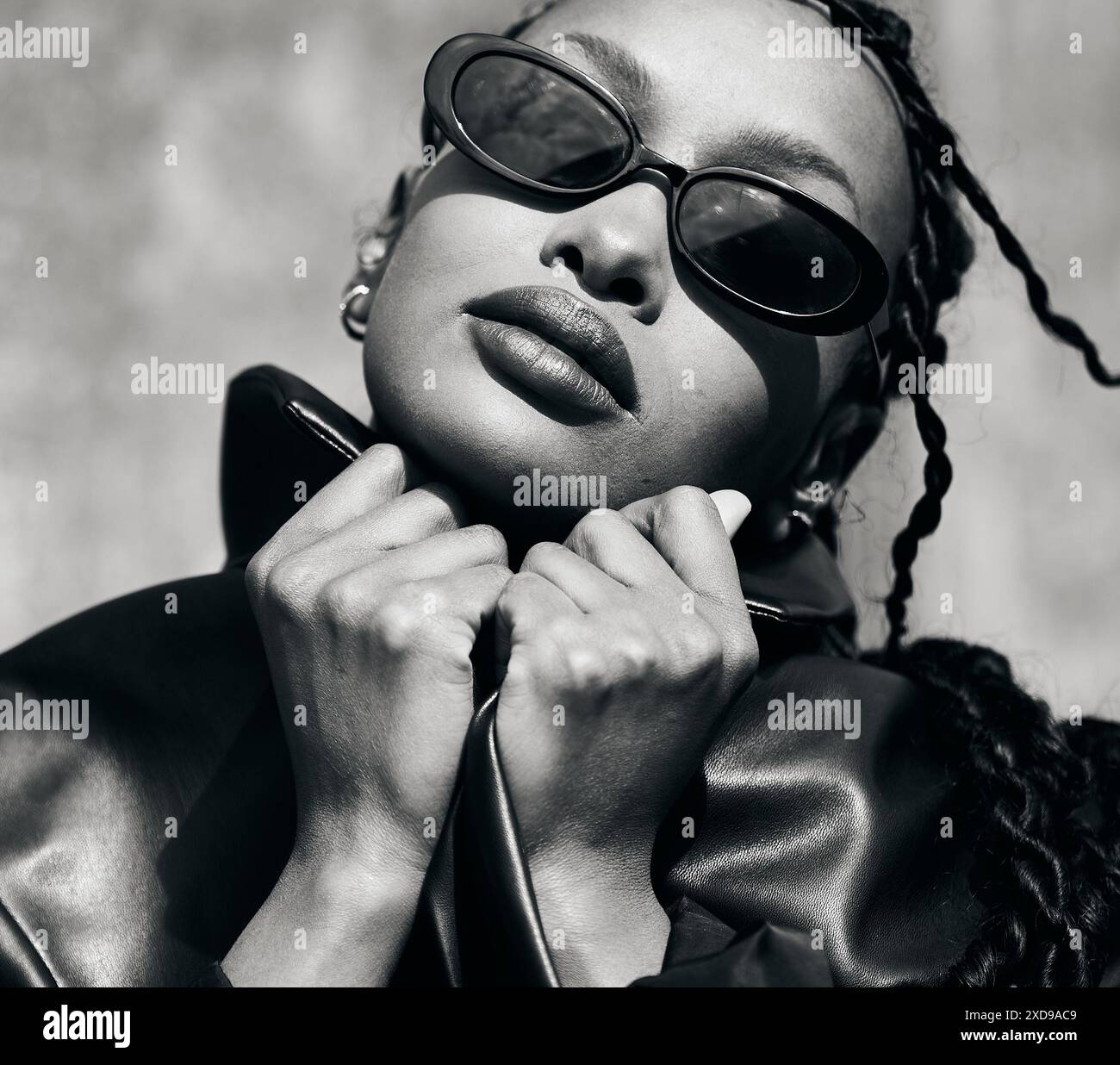 beautiful black model female holds collar of her jacket with both hands ...