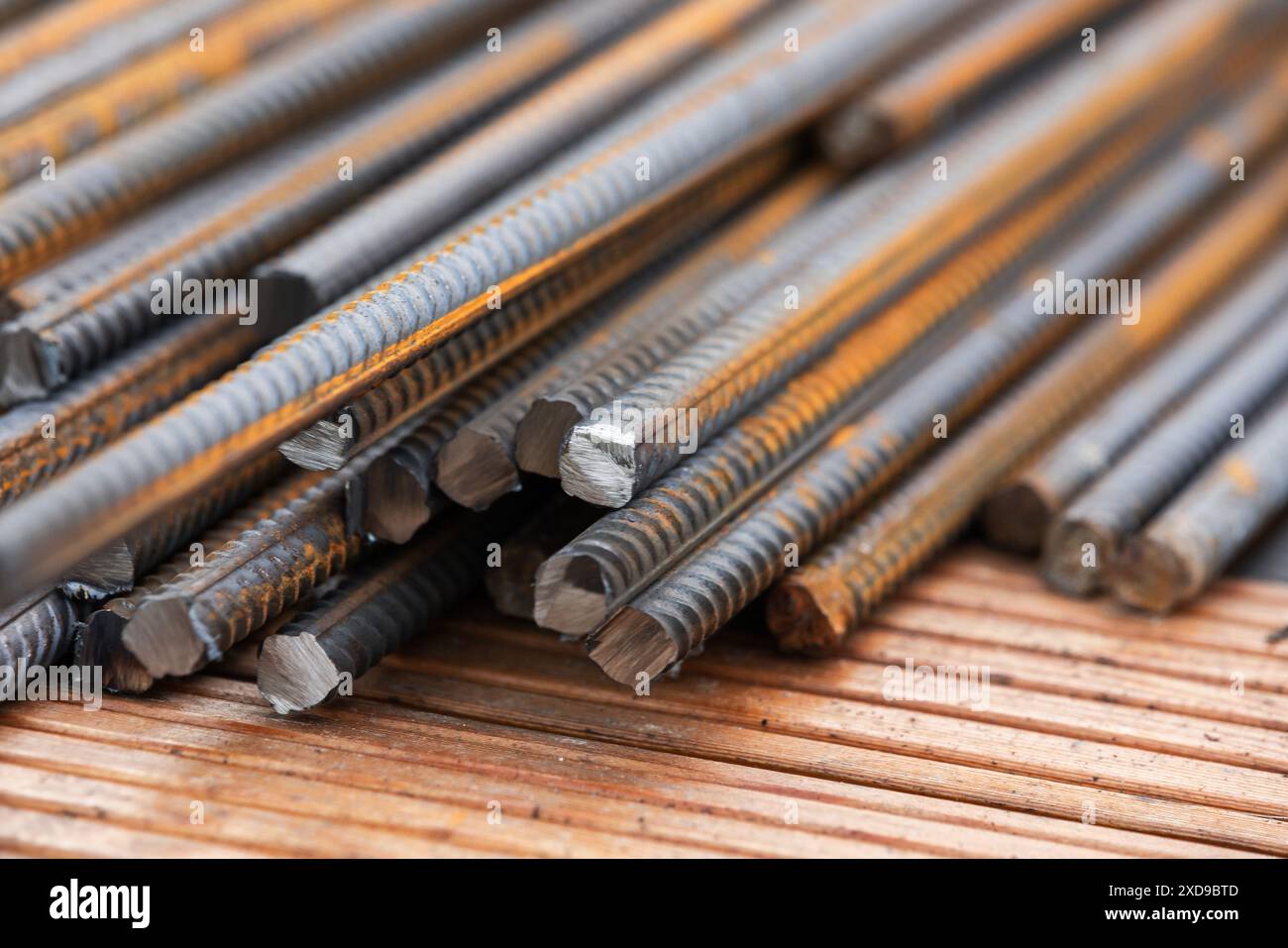 Construction iron rods with rust spots lay on a wooden desk, abstract ...