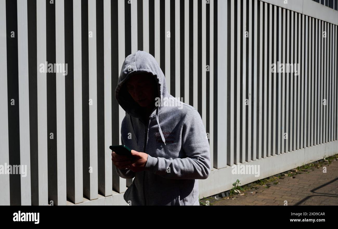 boy or man with grey hoodie pulled over face looks ominous as he walks ...