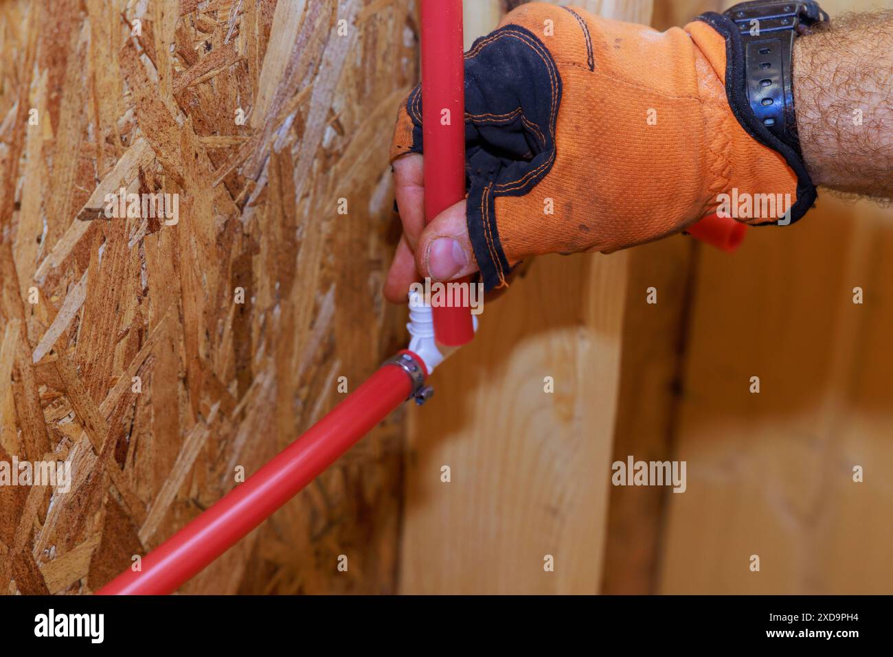 Plumber installs PVC plastic water pipes in walls of house connects ...