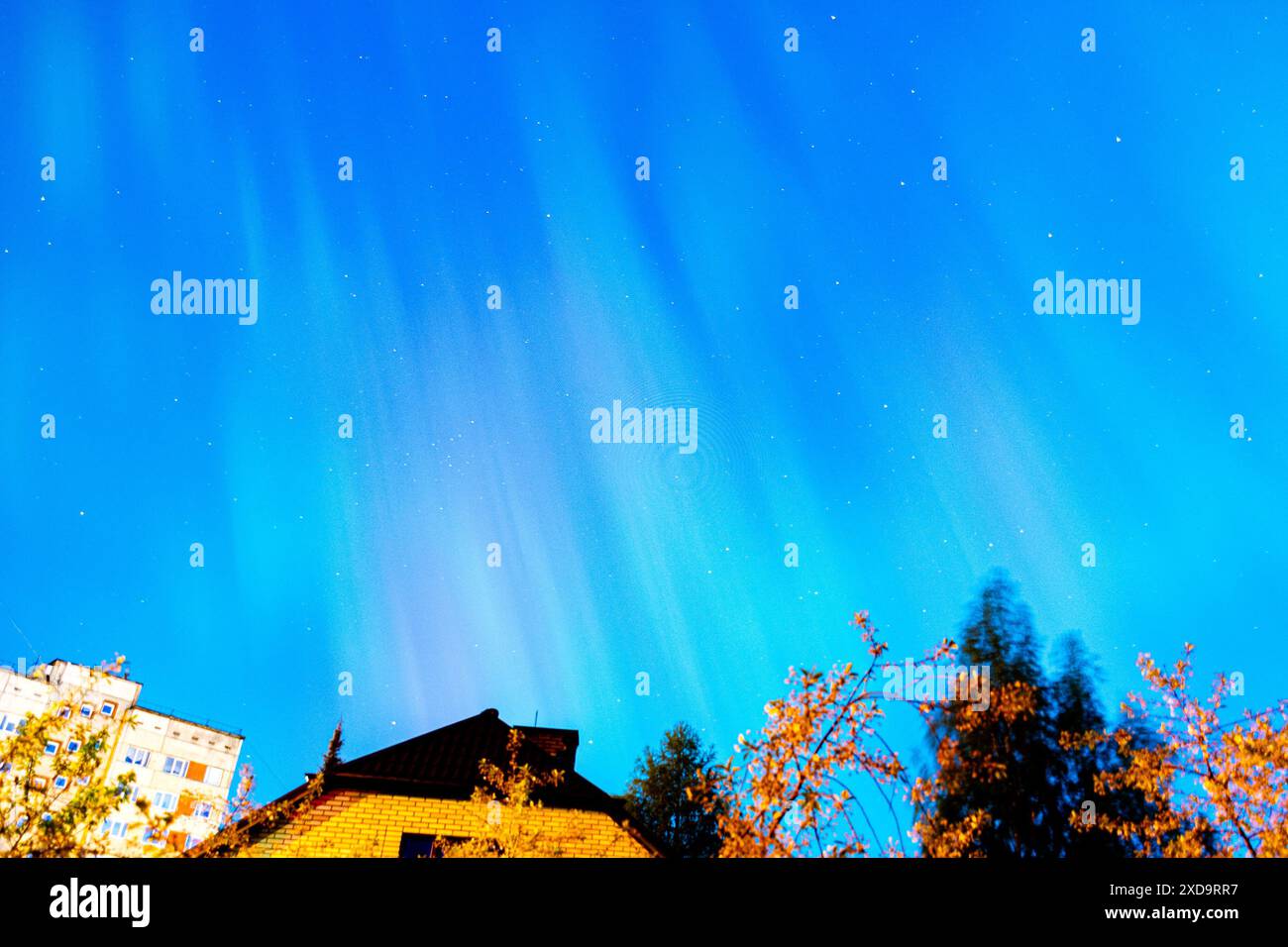 landscape with gorgeous northern lights over the roof of the house ...