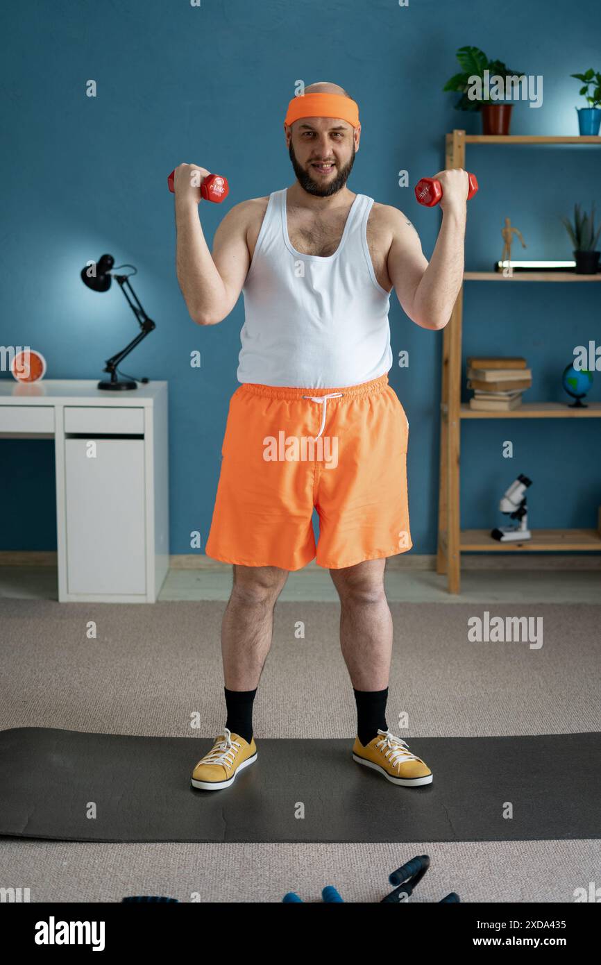 Funny Man Lifting Dumbbells in Home Gym Stock Photo - Alamy