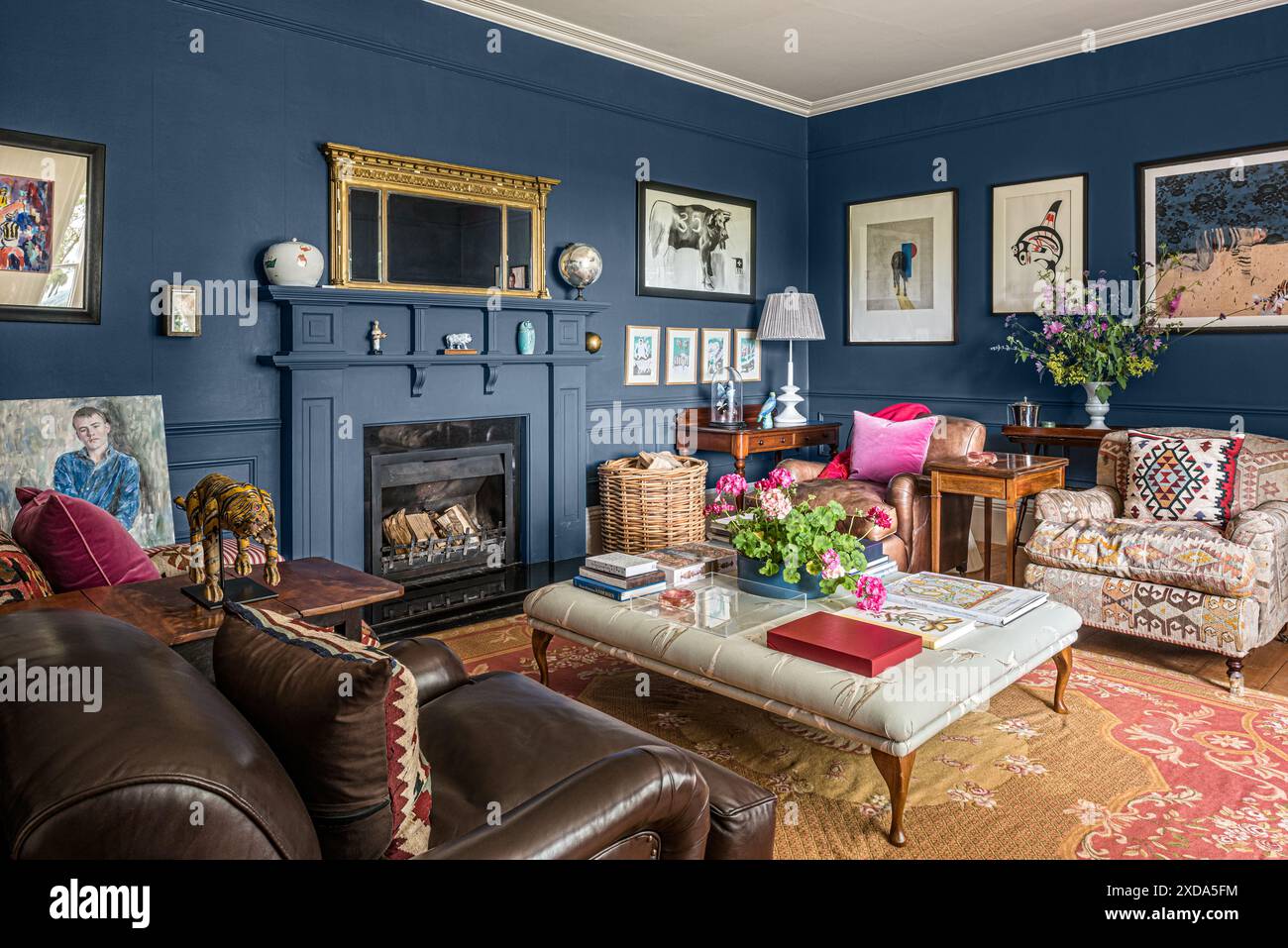 Dark blue walls offset prints and collected objects in living room of ...