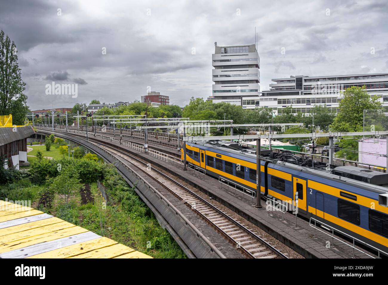Train on tracks passing through an urban area with modern buildings and ...
