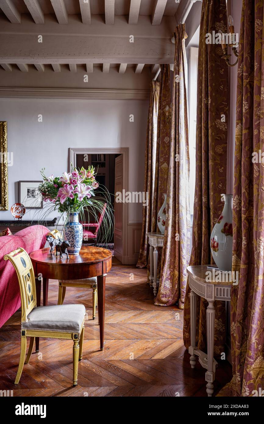 Cut flowers on side table with beamed ceilings in renovated stone-built ...