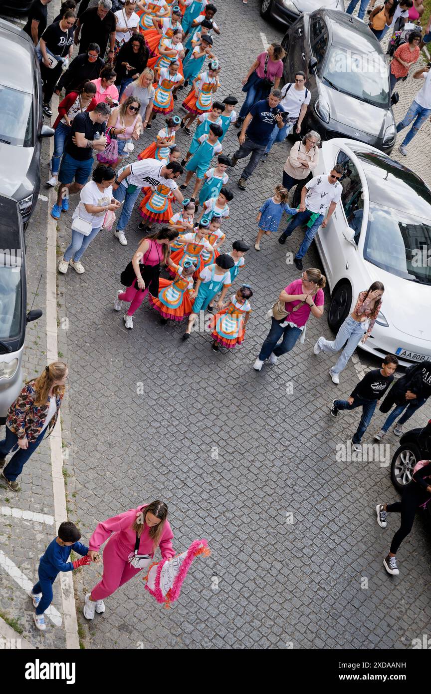 Children from a local school parading through a street in colorful ...
