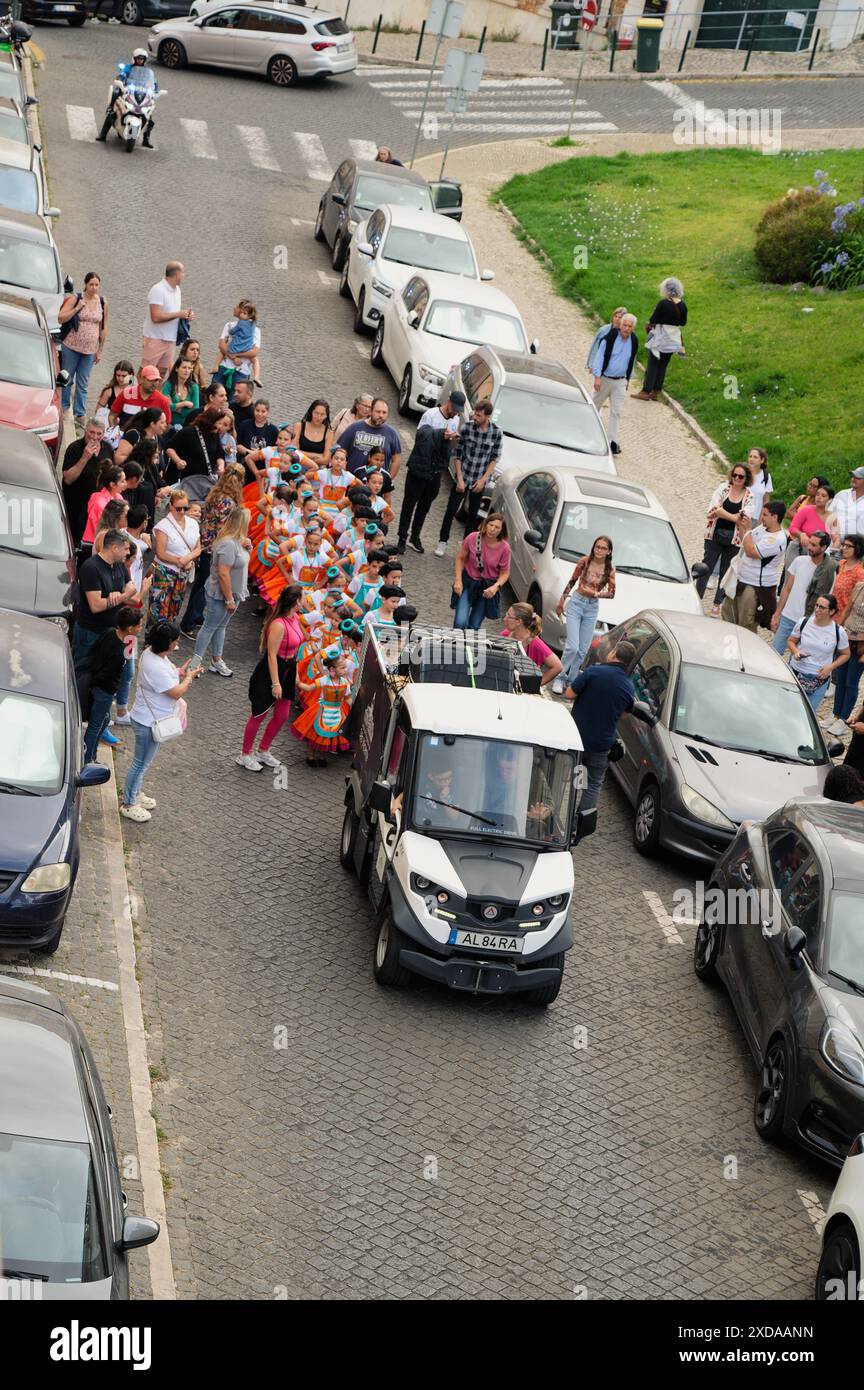 Children from a local school parading through a street in colorful ...