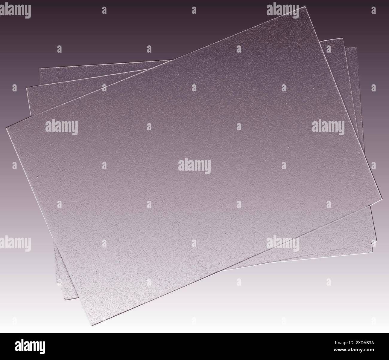 Overlapping gray metal sheets with a textured surface presented in a ...