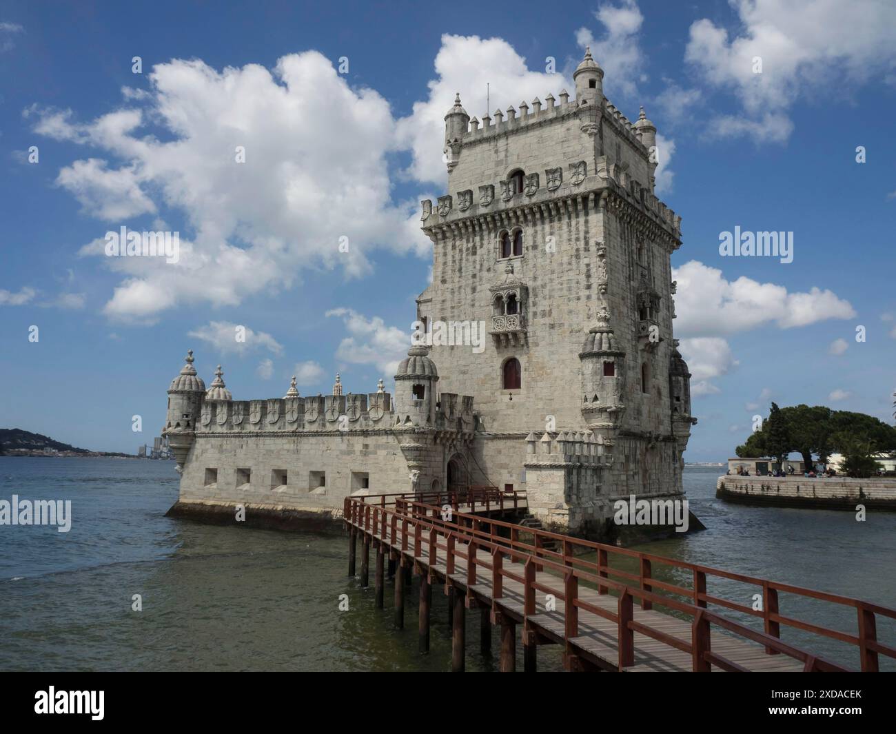 A historic river castle with stone structure and pier under a blue sky ...