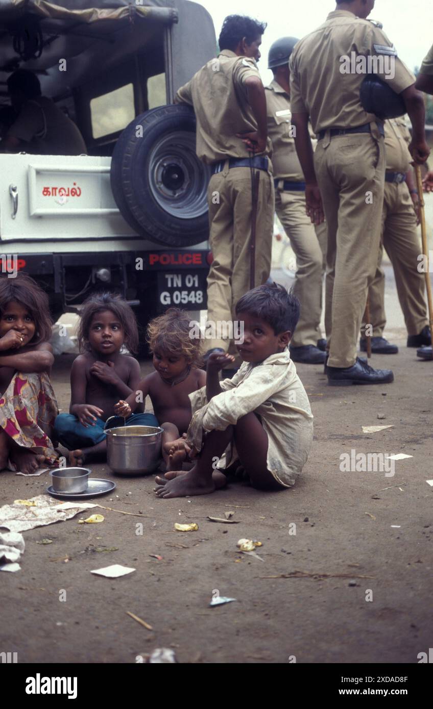poor children with some food in front of a group of police men on a ...