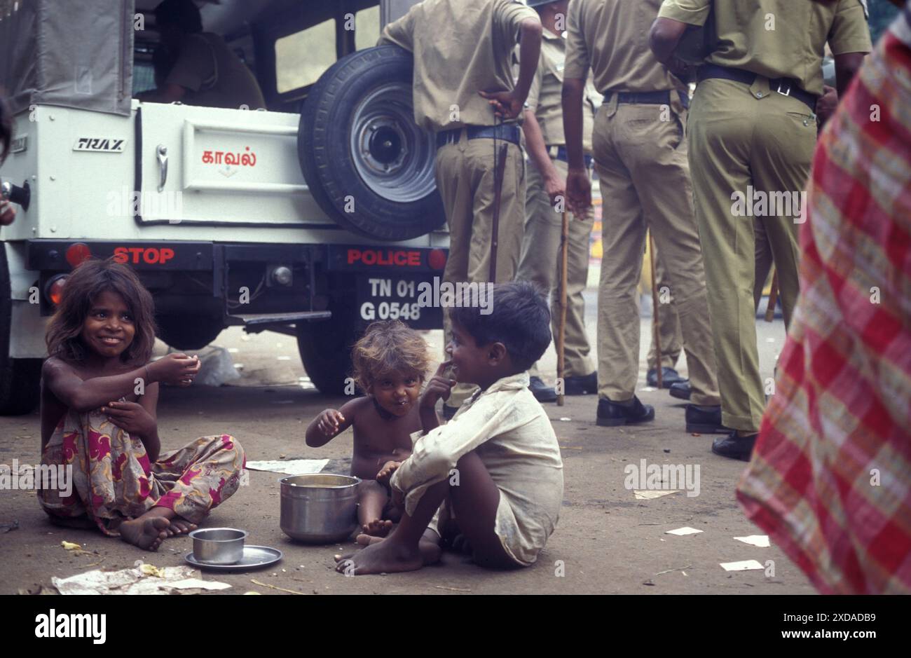 poor children with some food in front of a group of police men on a ...