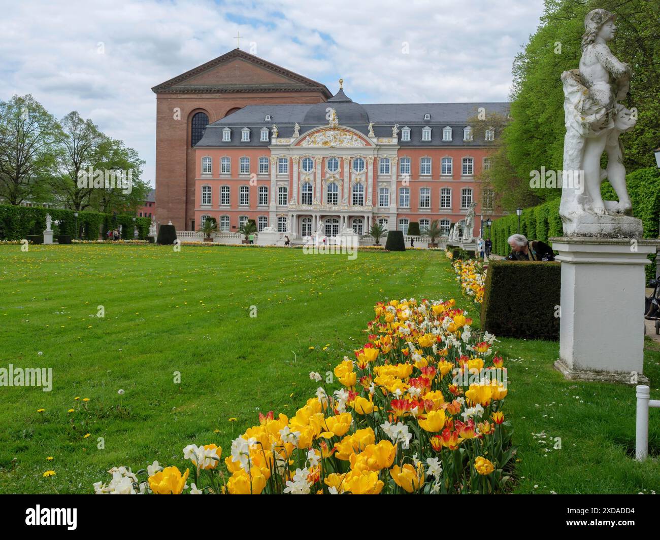 Magnificent historic building and flowering garden with a statue, trier ...