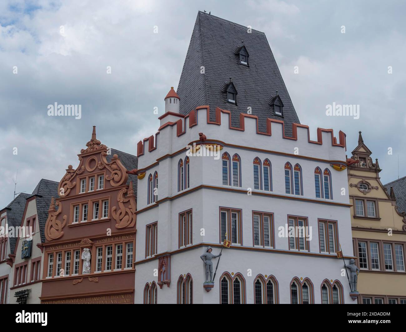 Row of detailed medieval buildings with towers and decorative facades ...