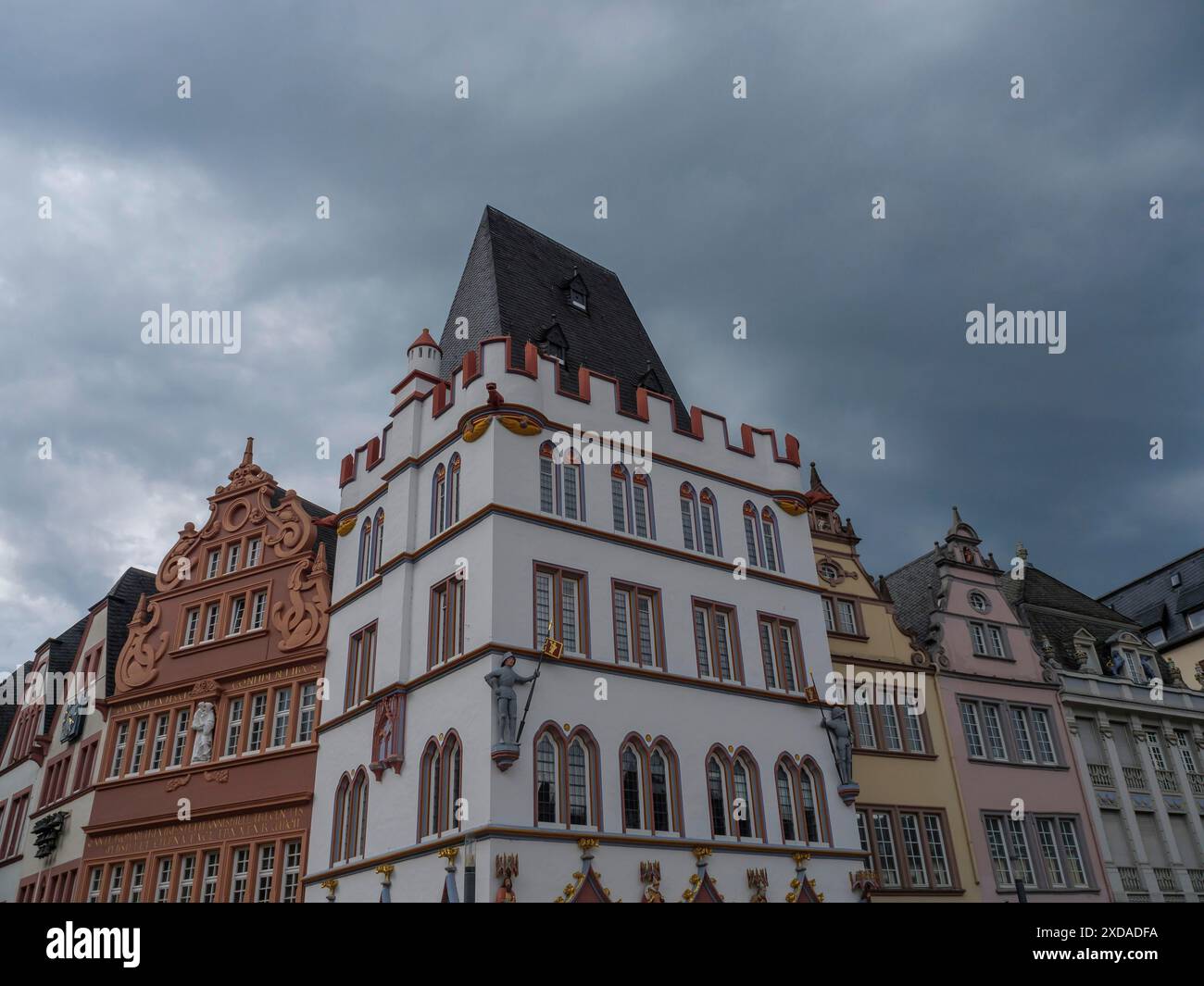Medieval building with decorated facades and dramatic cloudy sky, trier ...