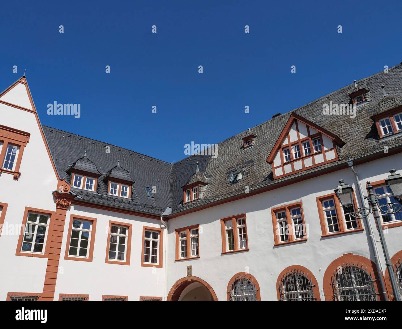 Historic building with many windows and a steep roof in front of a blue ...