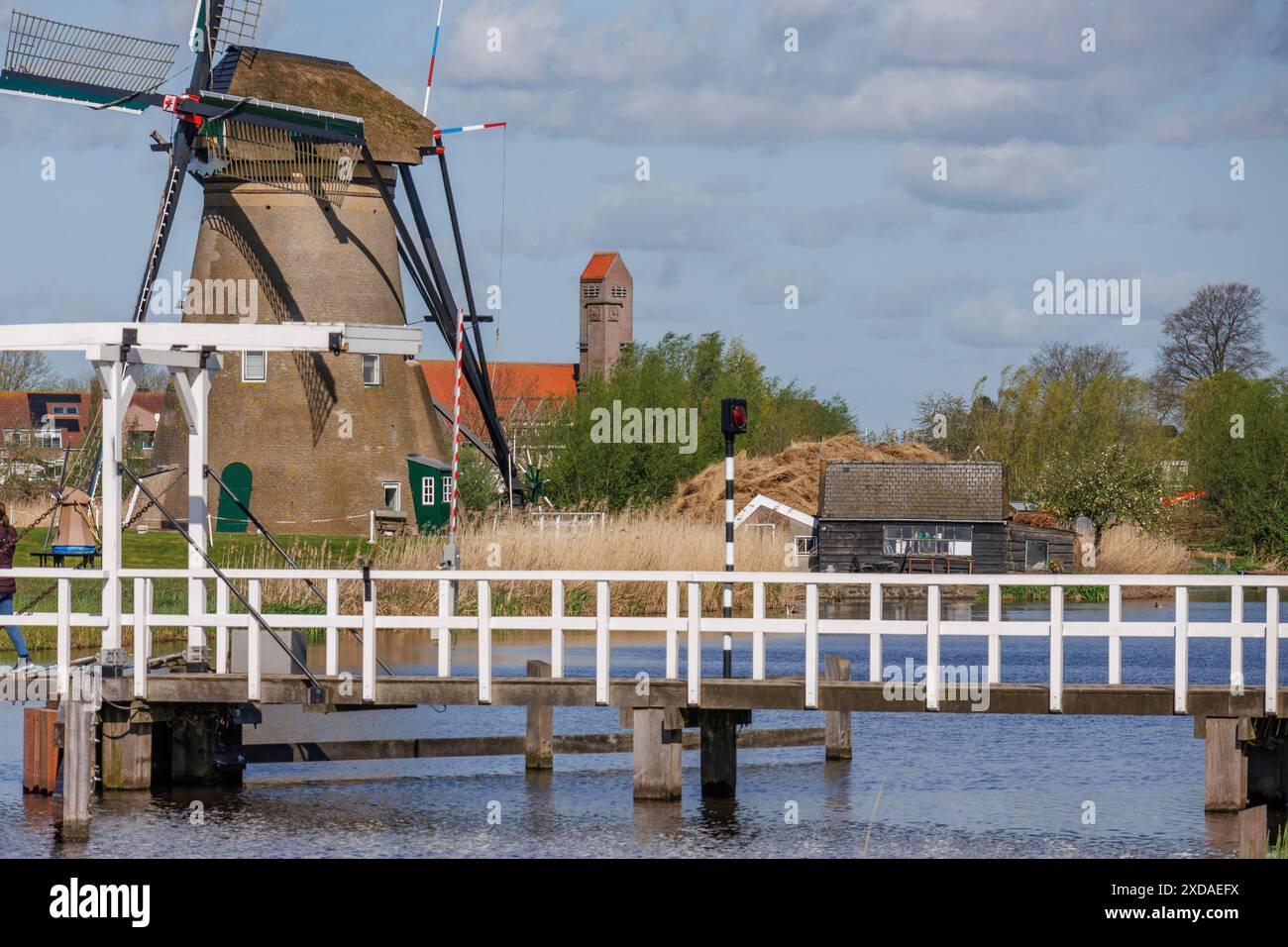 Windmill and wooden bridge over a river in a picturesque village with ...