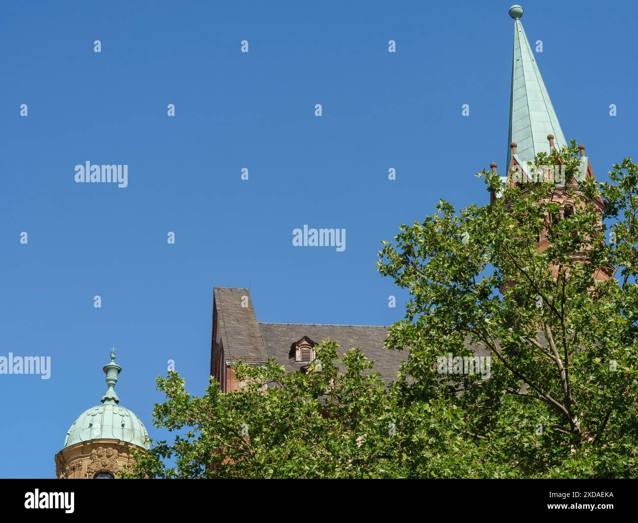 Gothic church with pointed towers and green trees towering into the ...
