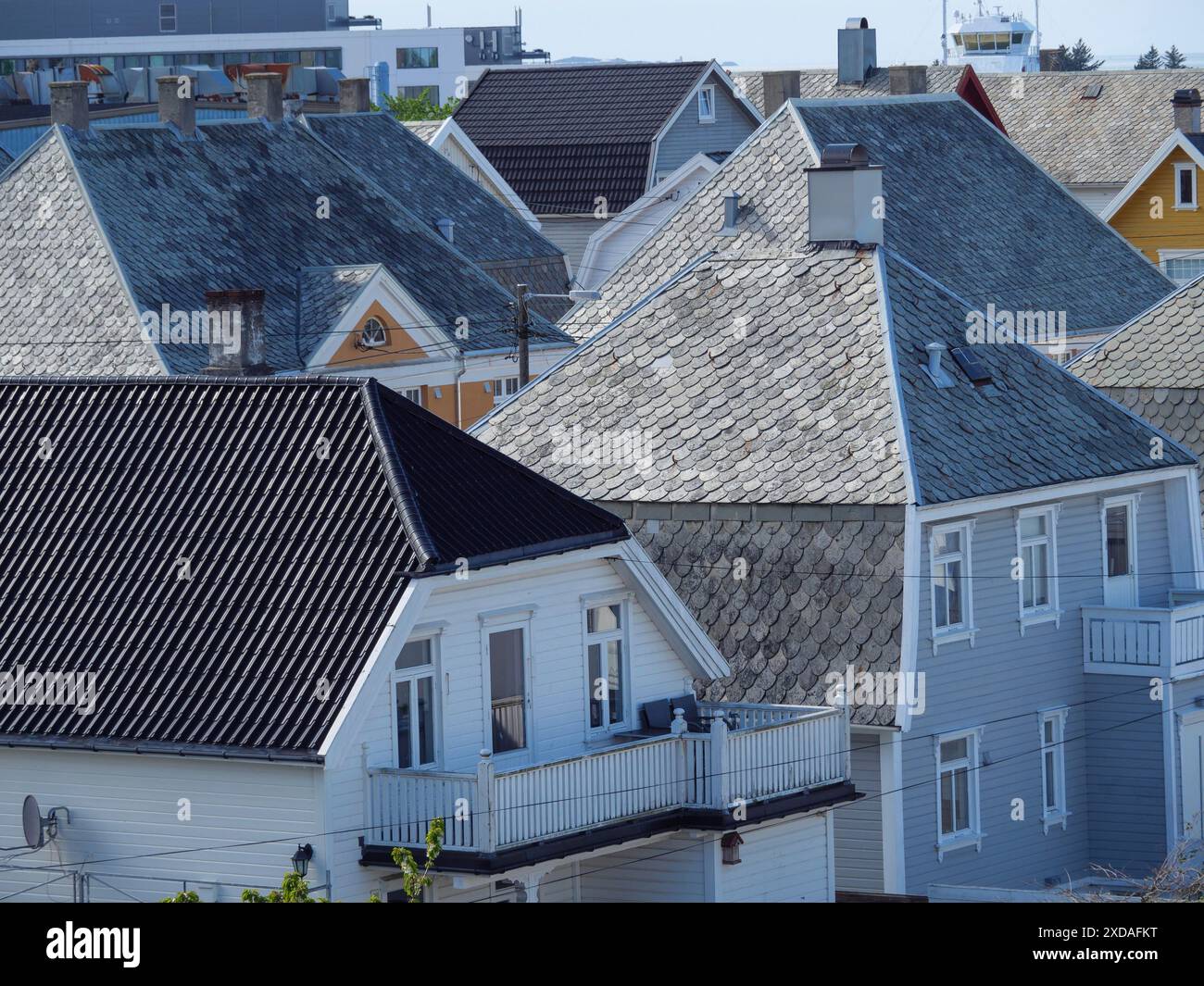 Urban view of different roof styles and houses with chimneys and old ...