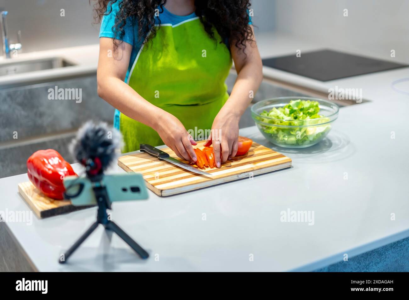 Female latin young vlogger making salad during live stream recording ...