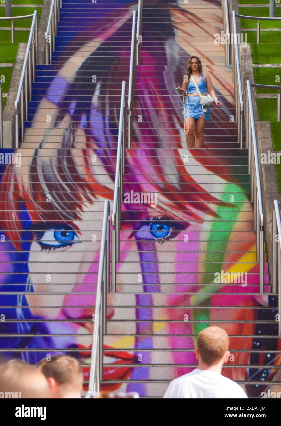 London, England, UK. 21st June, 2024. A woman walks down steps ...