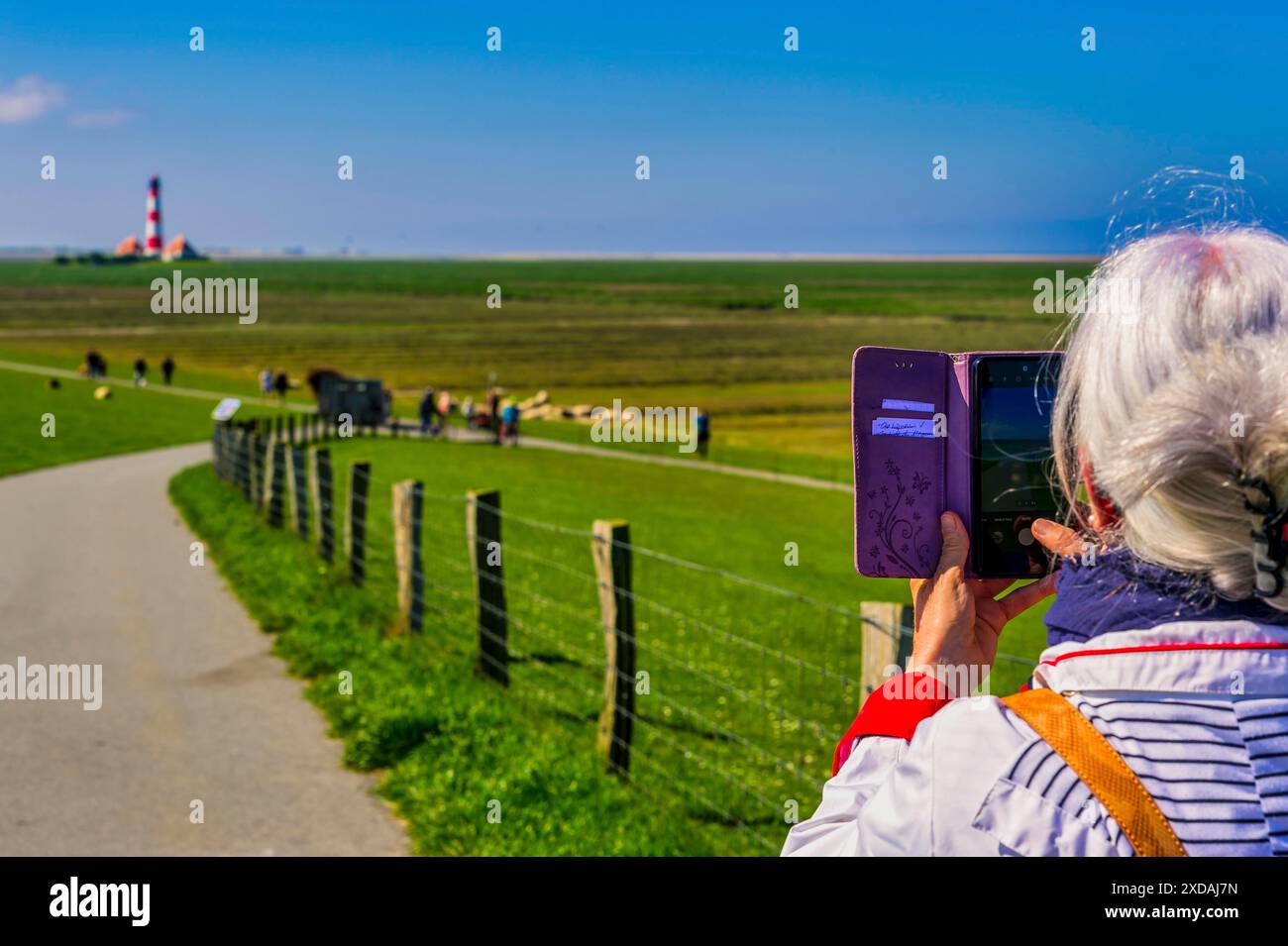 Woman, photographed with smartphone, lighthouse, North Sea, dike ...