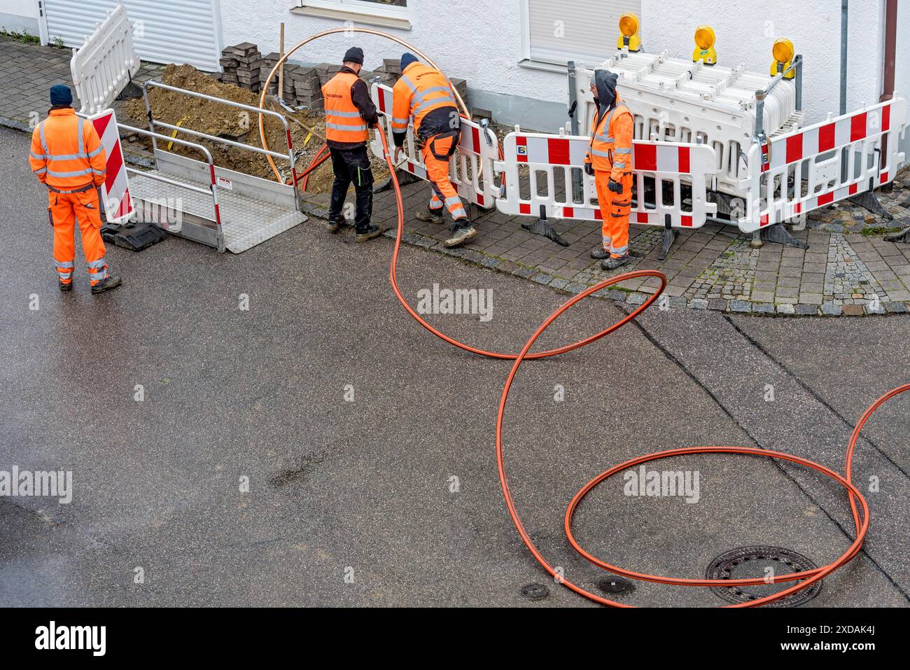 Construction workers laying fibre optic cable, cable trench ...