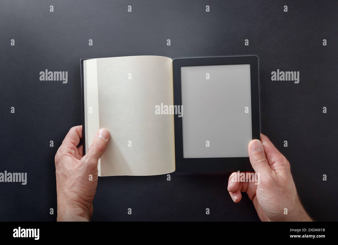 Reading comparison between paper and digital book with hands taking a ...