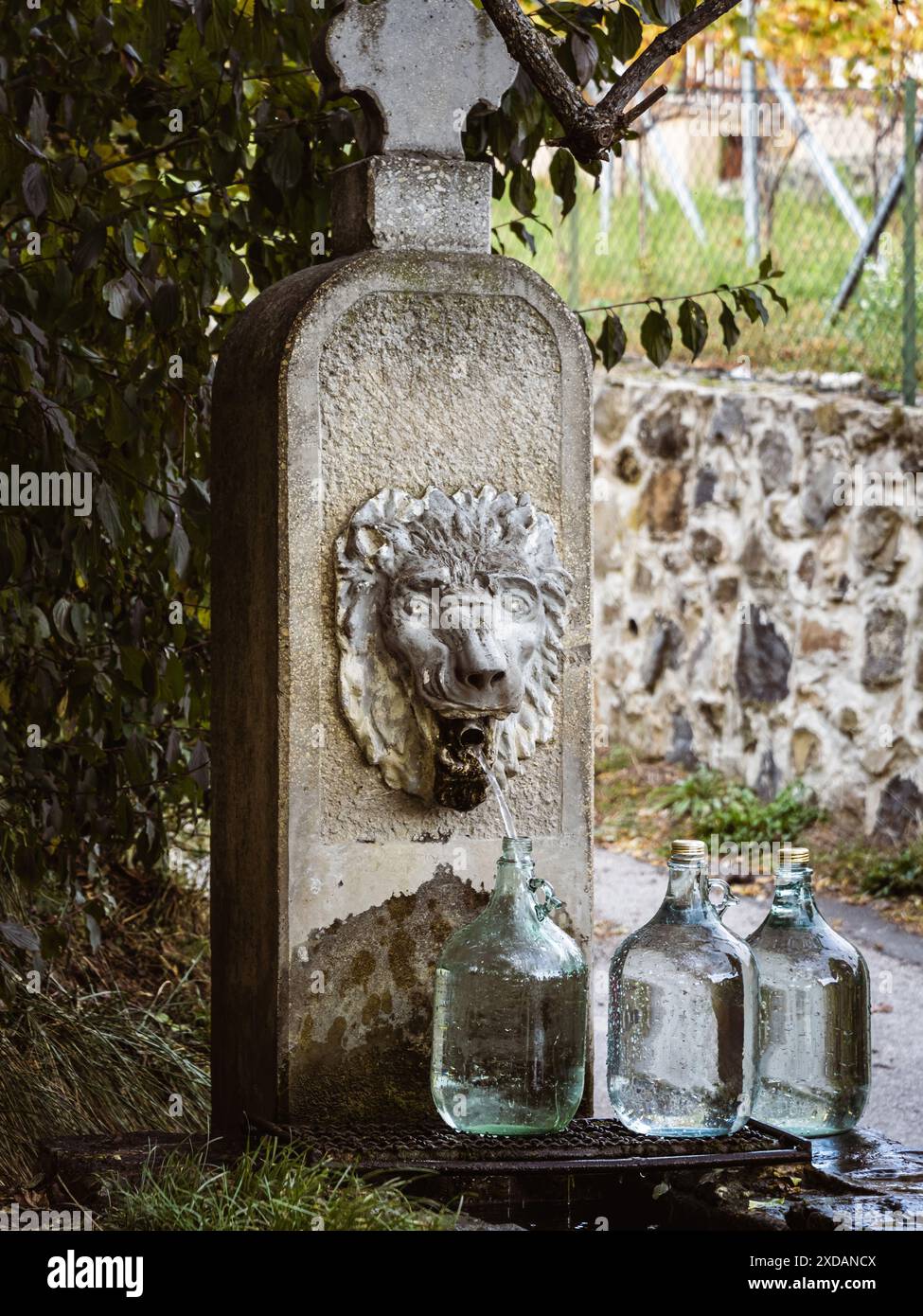 Filling glass water bottles at a public natural spring, crisp clear ...
