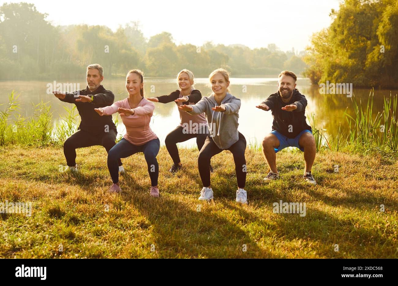 Group Of A Positive Athletes People Doing Squats In City Park Stock ...