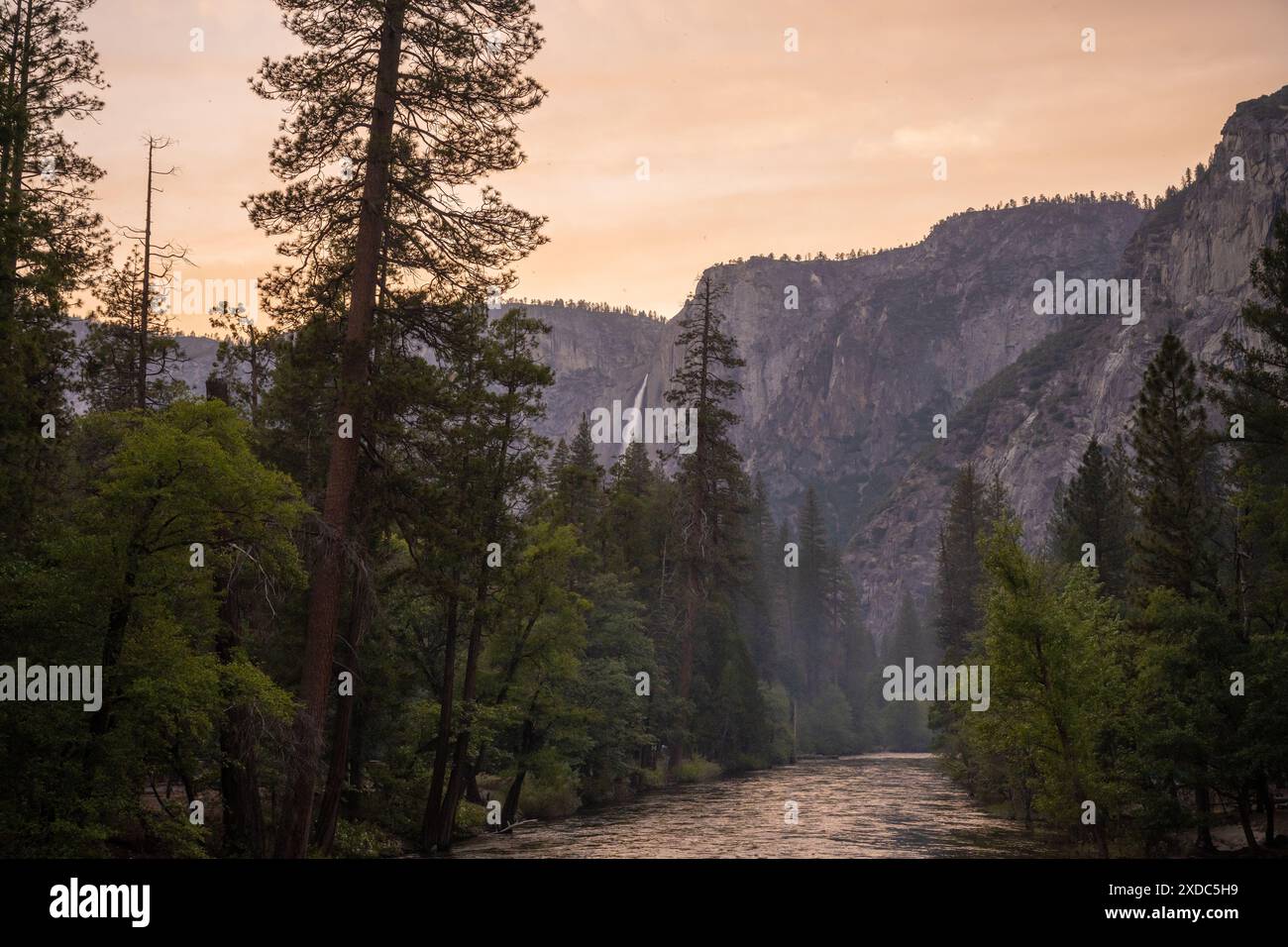 Orange Light Covers The Merced River Adn The Surrounding Walls Of ...