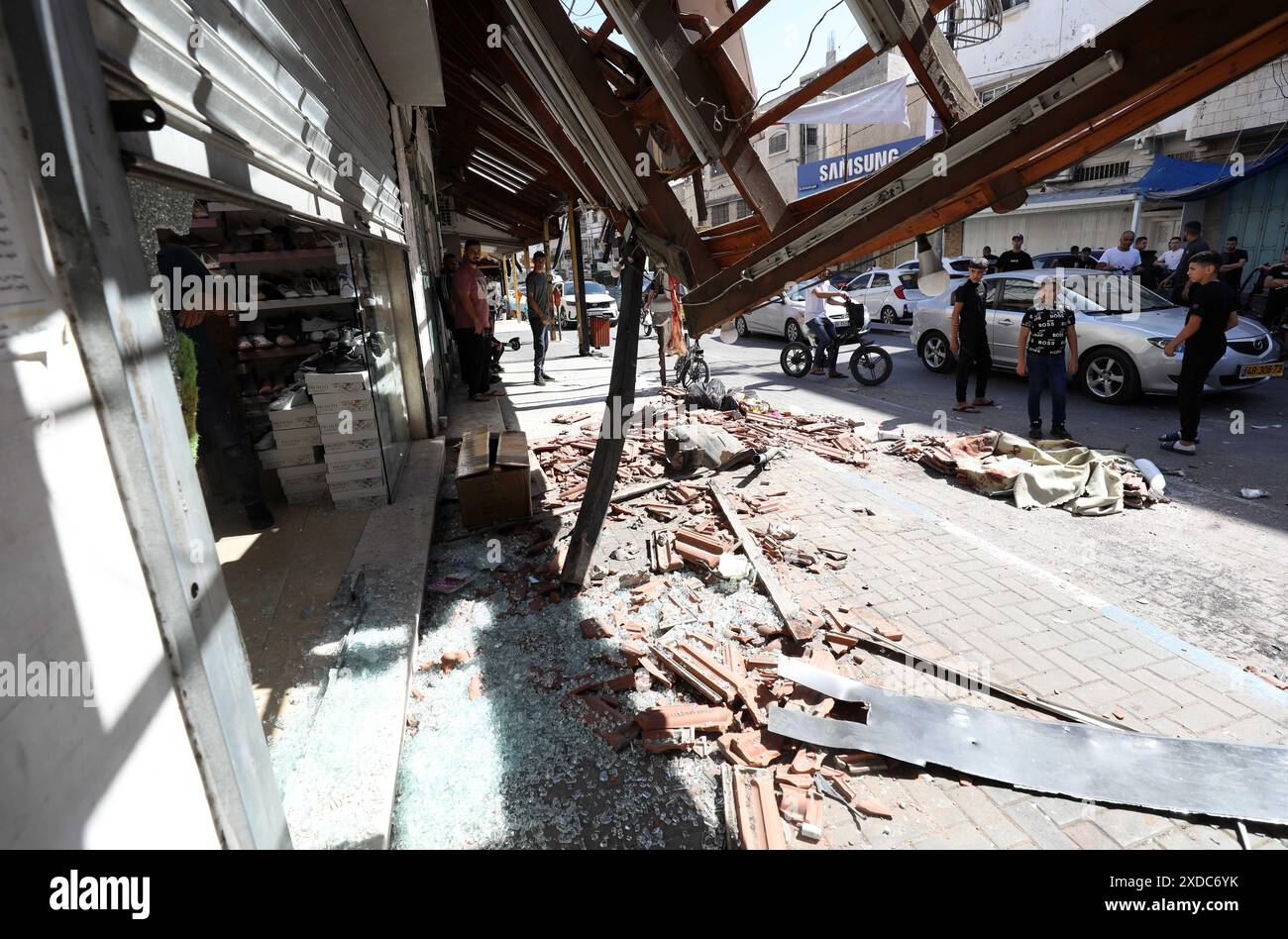Qalqilya. 21st June, 2024. People gather at the site where two ...