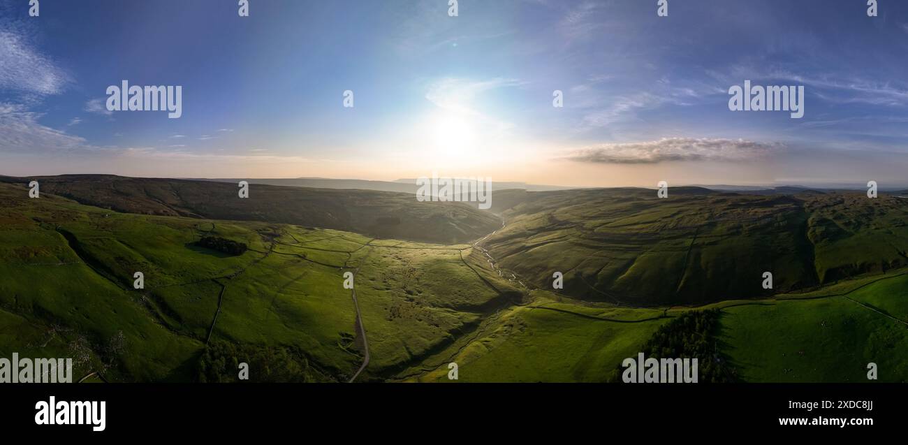 An expansive drone shot captures the beauty of a green valley bathed in ...