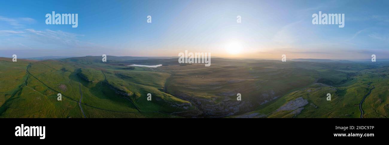 Aerial view capturing the sun setting over the hilly terrain near ...