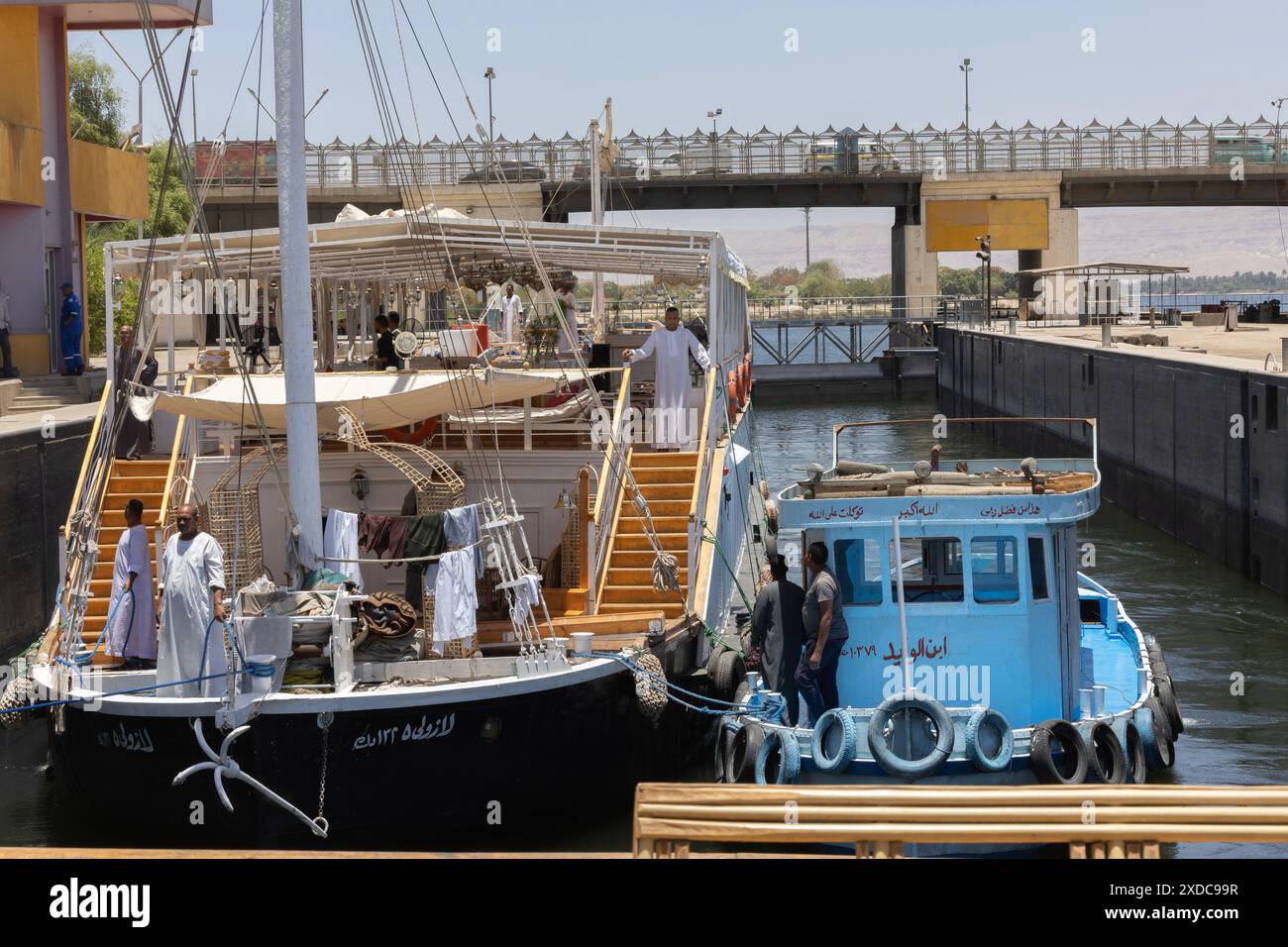 A dahabiya two-masted sailing boat and its tug in the rising waters of the Esna lock on the Nile ...