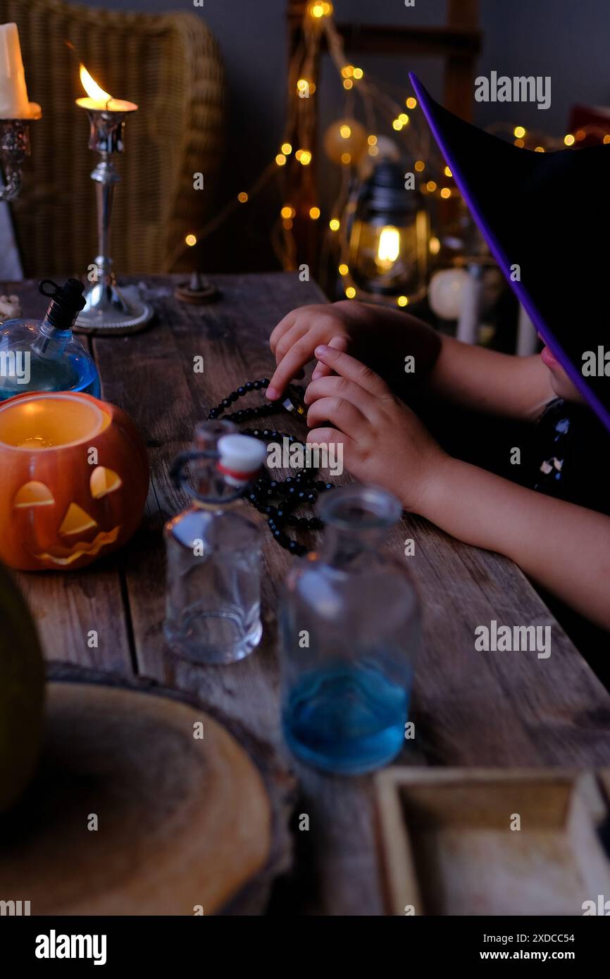 child makes magic out of focus, girl 3 years old in witch hat learns ...