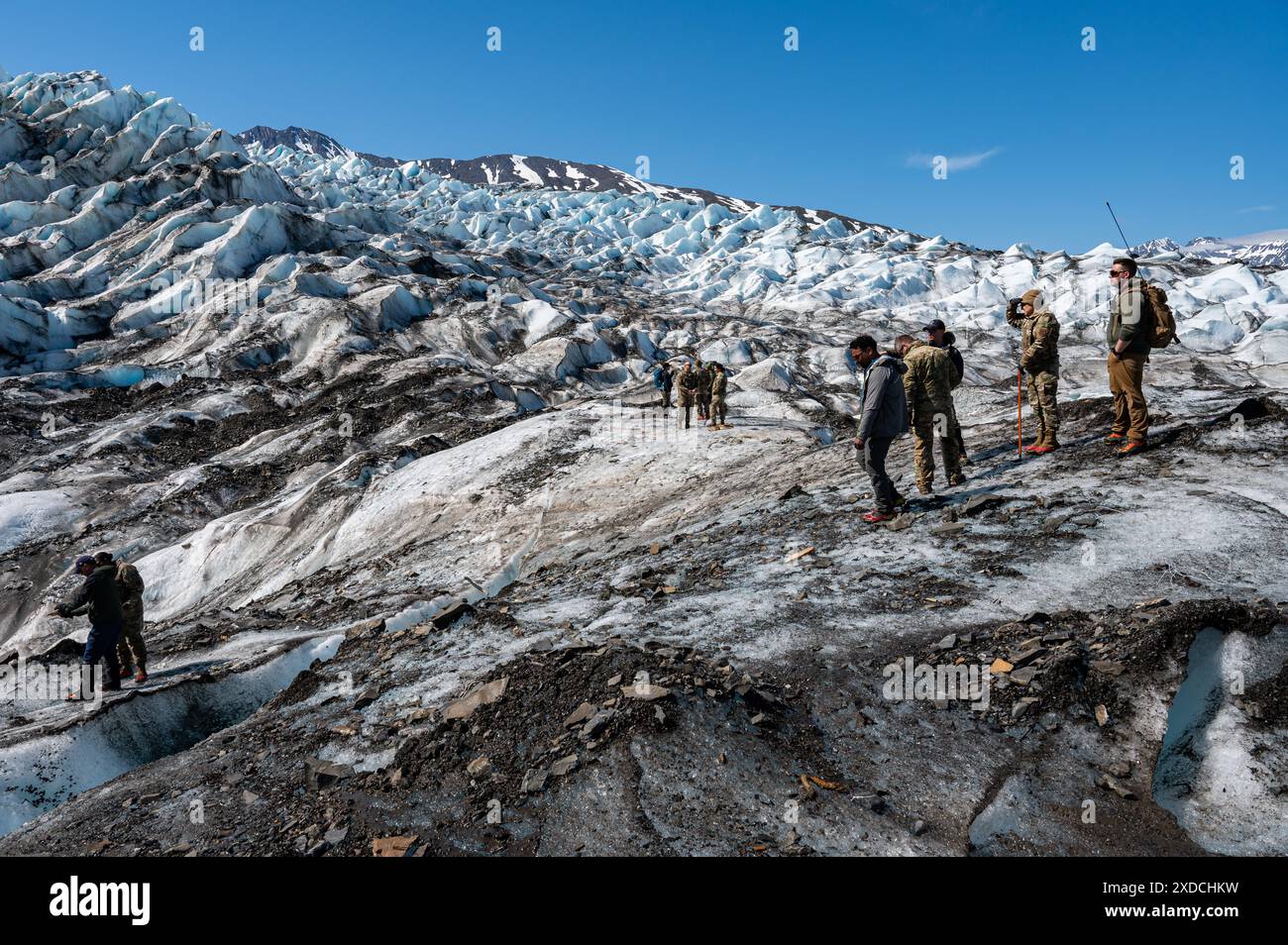 Distinguished visitors look across a debris field at Colony Glacier ...