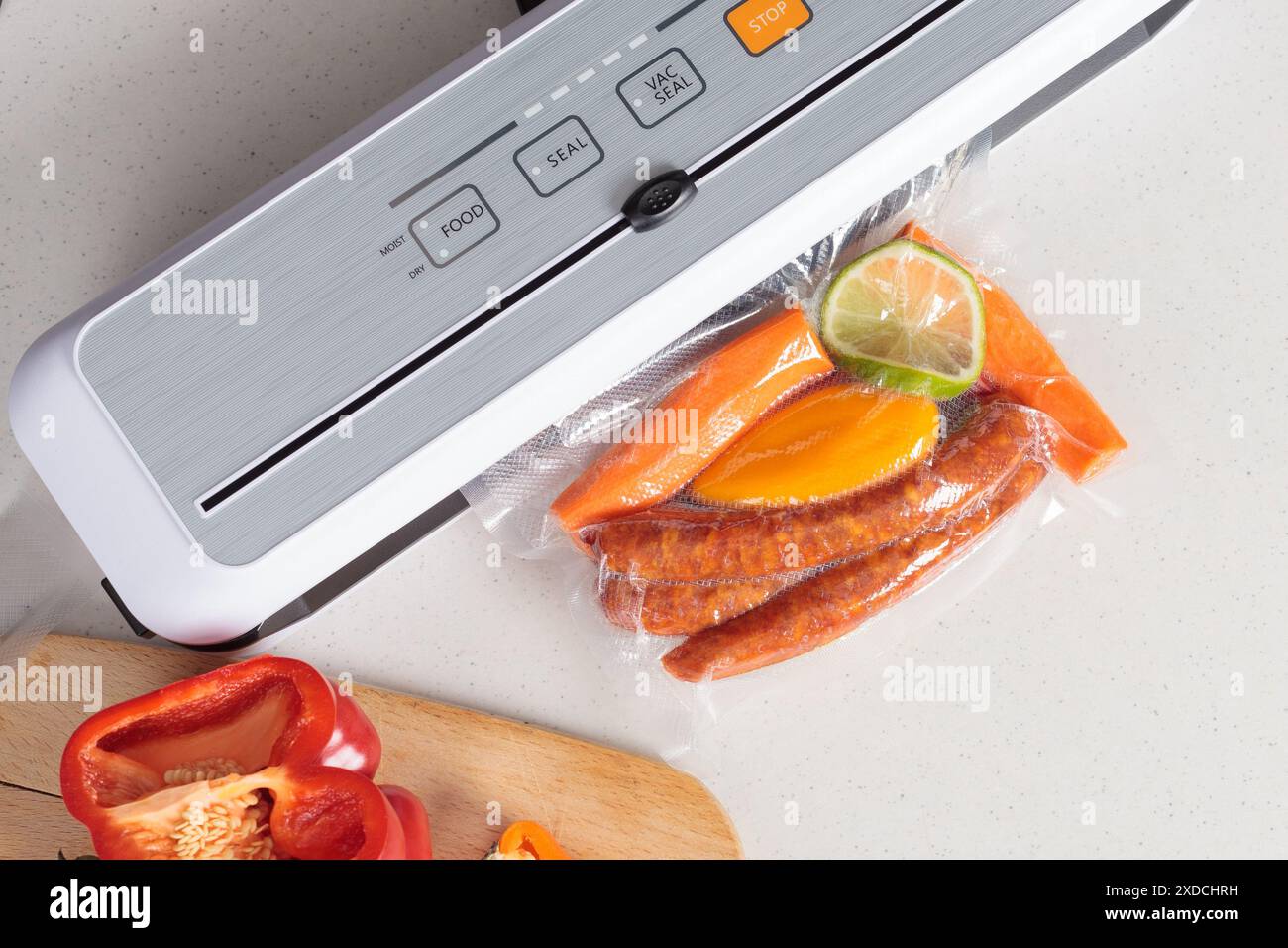 Vacuum food sealer machine sealing a bag of mixed vegetables and ...