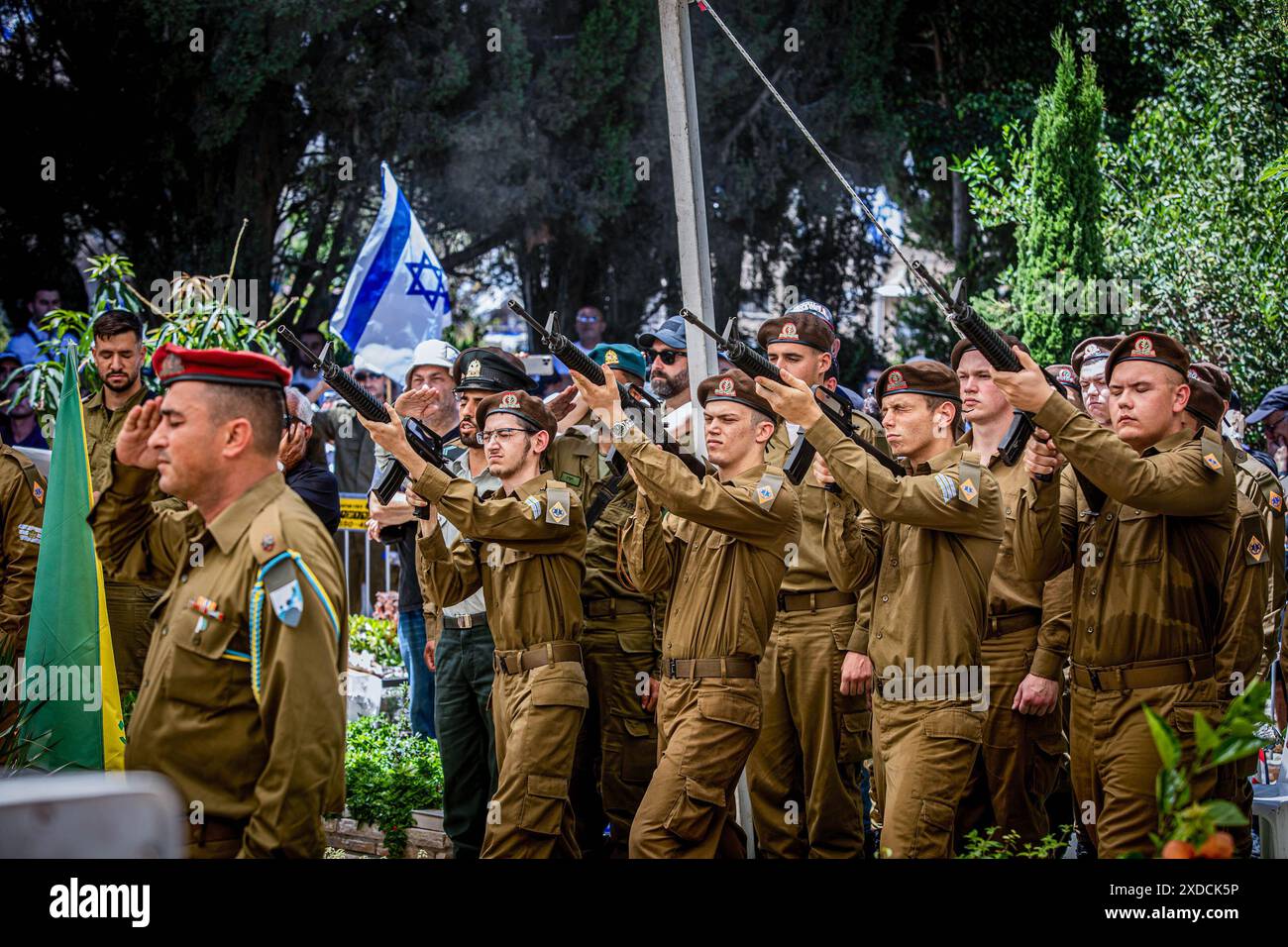 An Israeli honor guard fire their weapons during the funeral ceremony ...