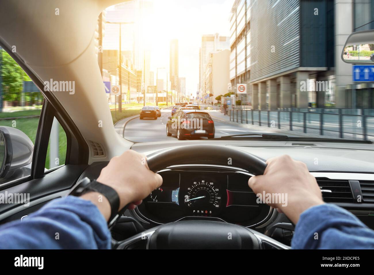 Driving car, view from driver's seat. Man holding hands on steering ...