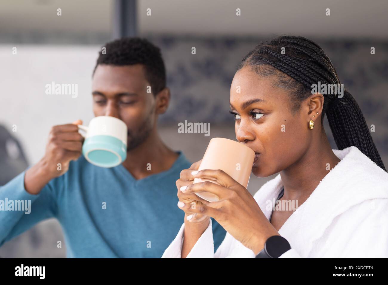 Young Black couple enjoying morning at home, drinking coffee together ...