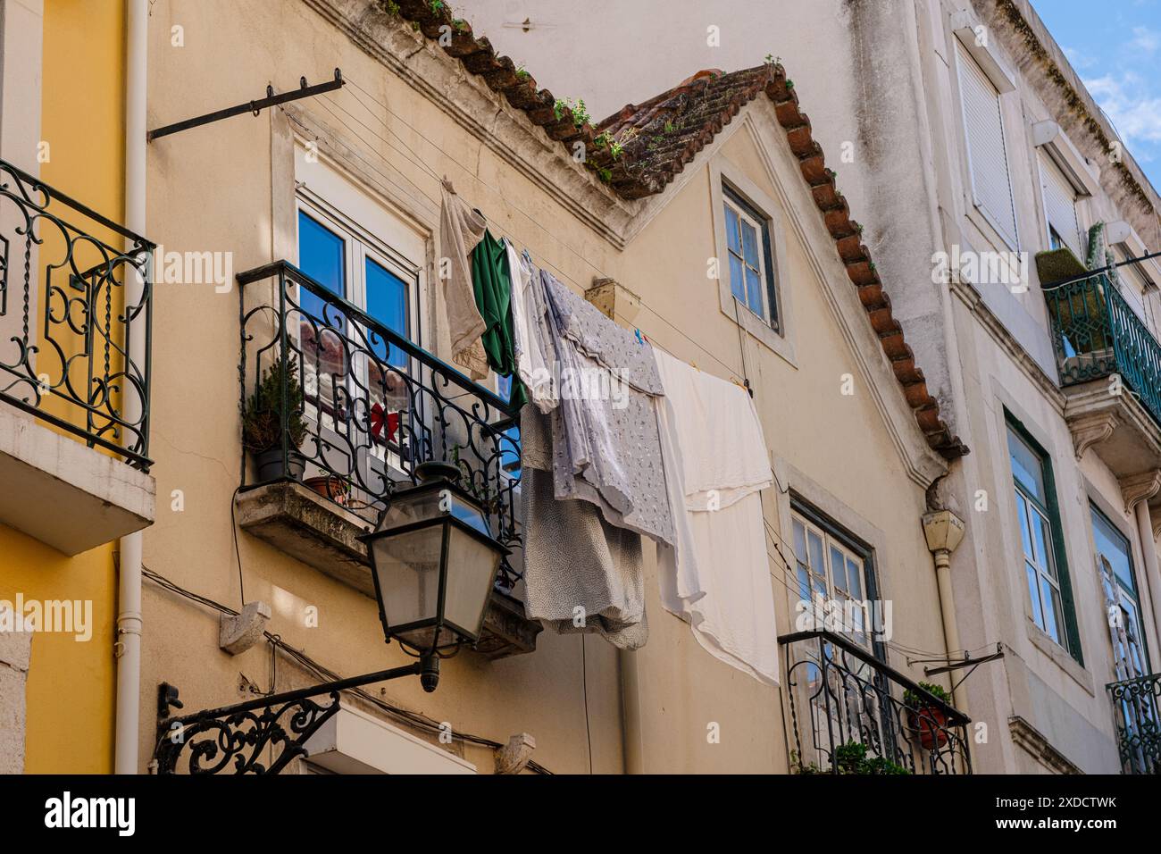 Street of Lisbon city. Washed clothes hang from the balcony and dry ...