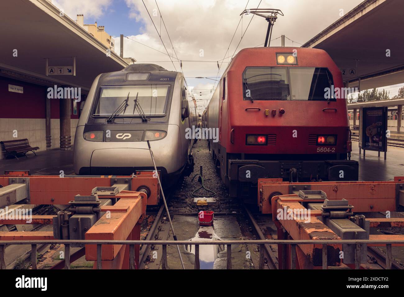 Modern passenger trains stand under the roof of a railway station in ...
