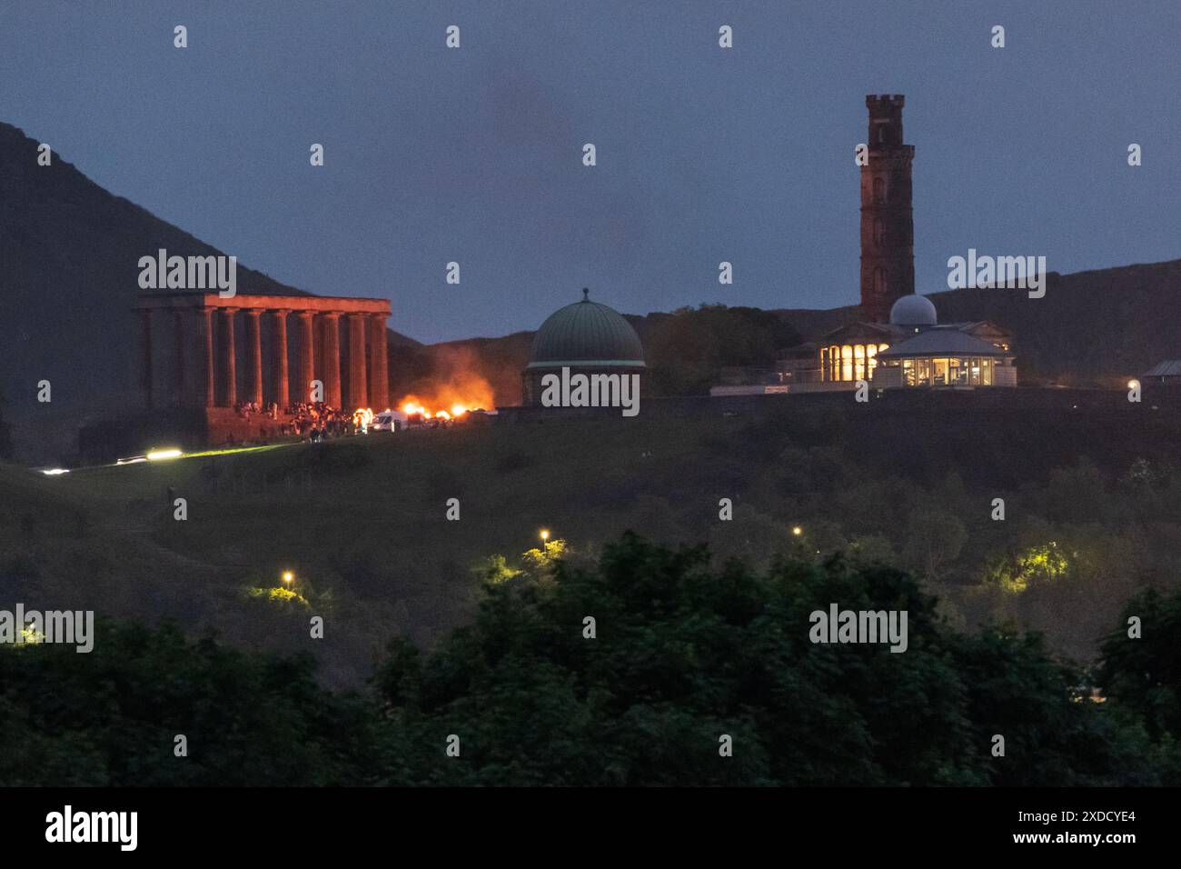 Edinburgh, 21st June, 2024. Bonfires and Fire Jugglers light the summit ...